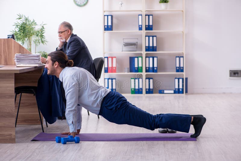 Two Employees Doing Physical Exercises at Workplace Stock Photo - Image ...
