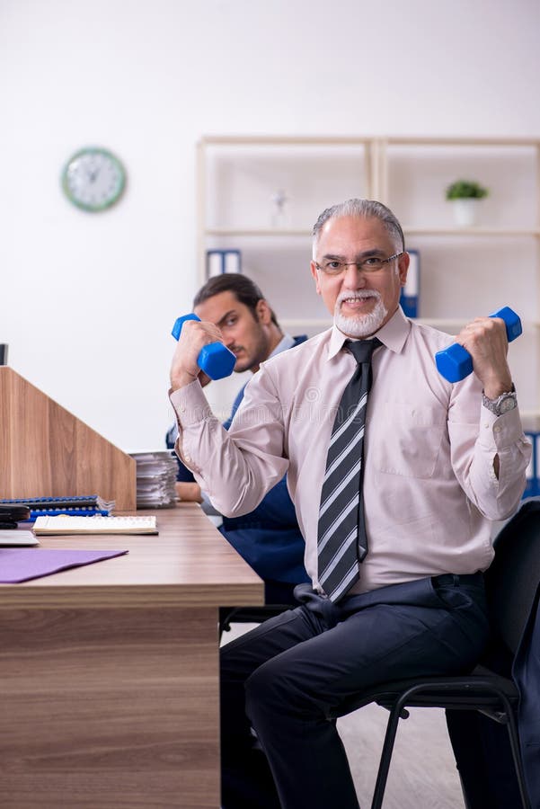 Two Employees Doing Physical Exercises at Workplace Stock Image - Image ...