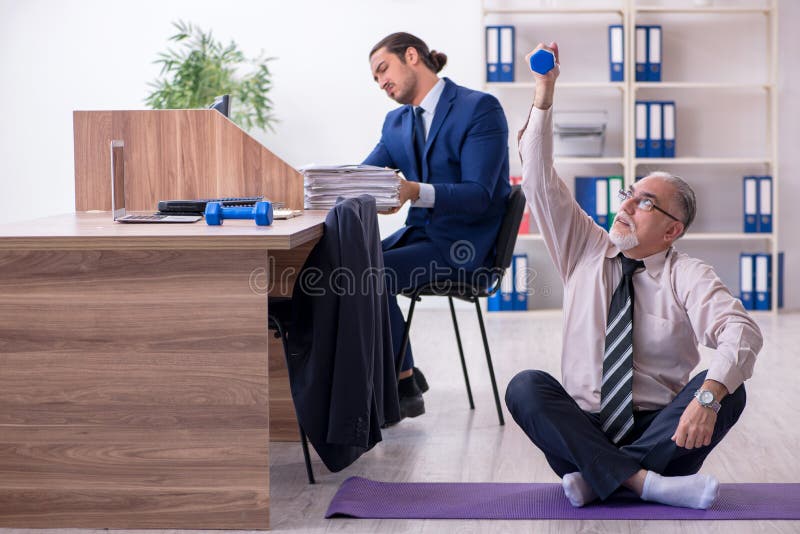 Two Employees Doing Physical Exercises at Workplace Stock Image - Image ...