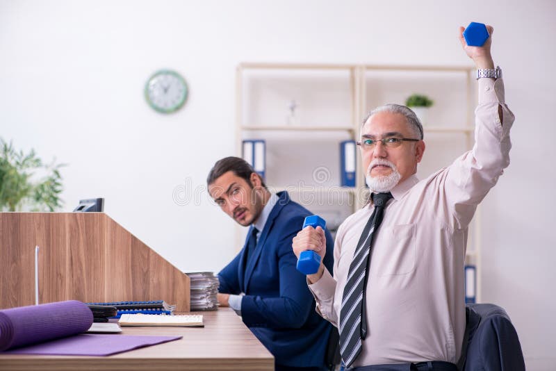 Two Employees Doing Physical Exercises at Workplace Stock Image - Image ...