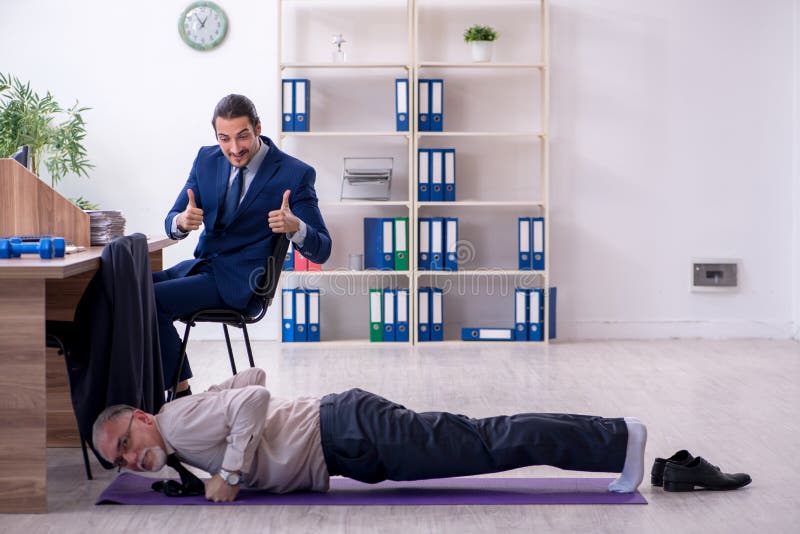 Two Employees Doing Physical Exercises at Workplace Stock Image - Image ...