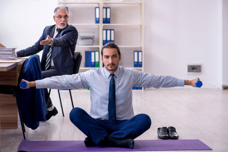 Two Employees Doing Physical Exercises at Workplace Stock Image - Image ...