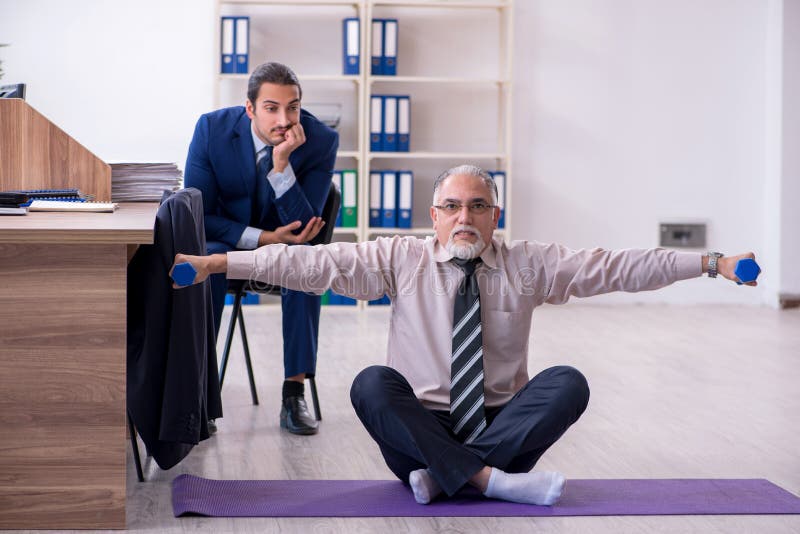 Two Employees Doing Physical Exercises at Workplace Stock Image - Image ...