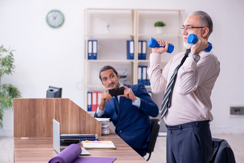 Two Employees Doing Physical Exercises at Workplace Stock Image - Image ...