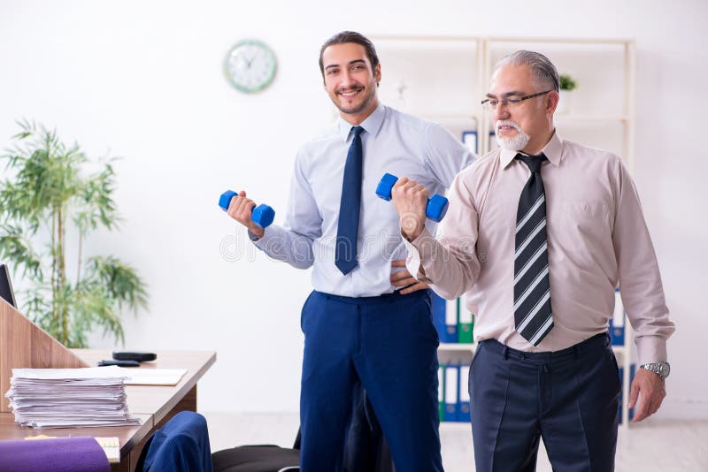Two Employees Doing Physical Exercises at Workplace Stock Image - Image ...
