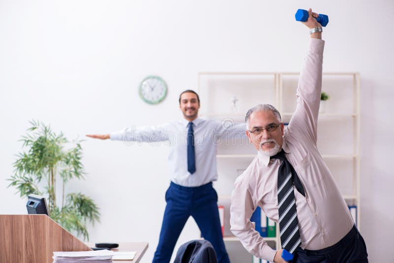 Two Employees Doing Physical Exercises at Workplace Stock Photo - Image ...