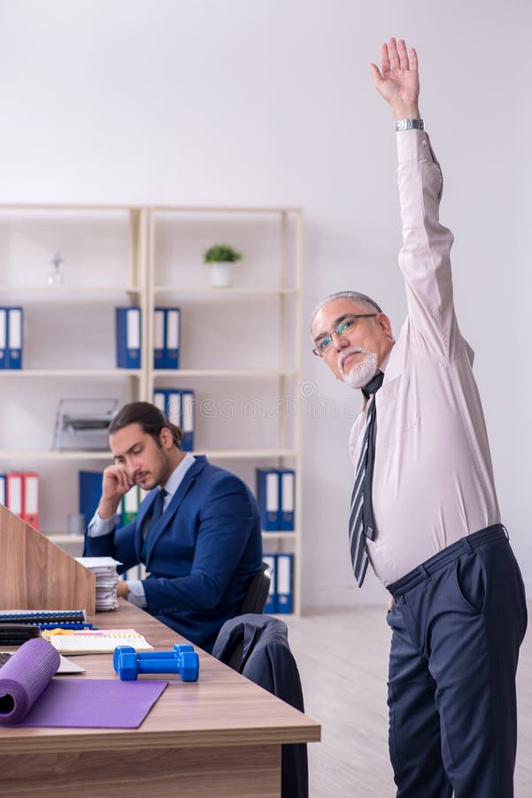 Two Employees Doing Physical Exercises at Workplace Stock Photo - Image ...