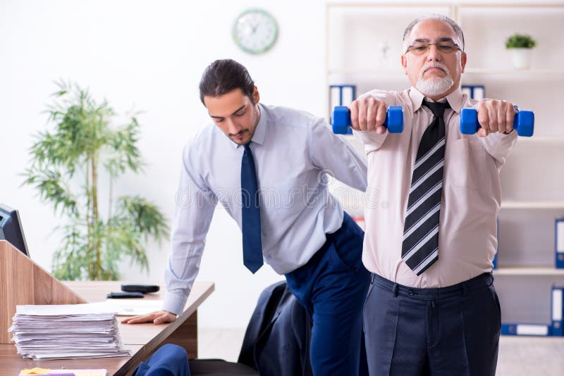 Two Employees Doing Physical Exercises at Workplace Stock Image - Image ...