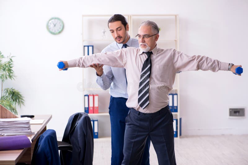 Two Employees Doing Physical Exercises at Workplace Stock Image - Image ...