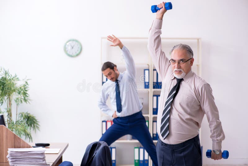 Two Employees Doing Physical Exercises at Workplace Stock Image - Image ...