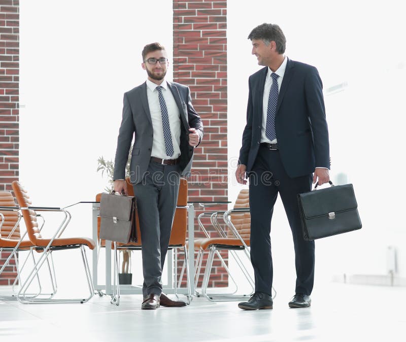 Two Businessmen Walking Along in Modern Office Building Stock Photo ...