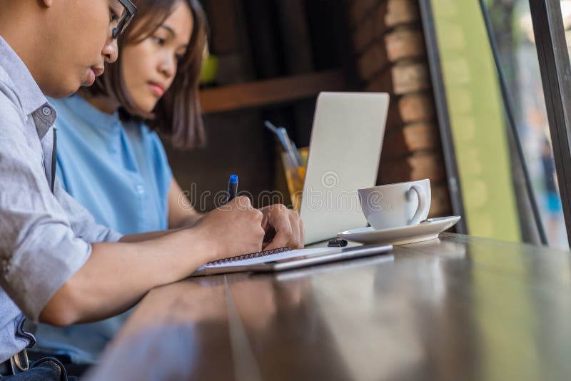 Two Employees Writing Notes and Working on Laptop Stock Image - Image ...