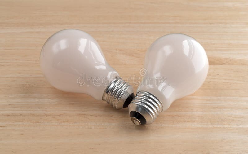 Two Energy Saving Light Bulbs on a Wood Table Stock Image - Image of ...