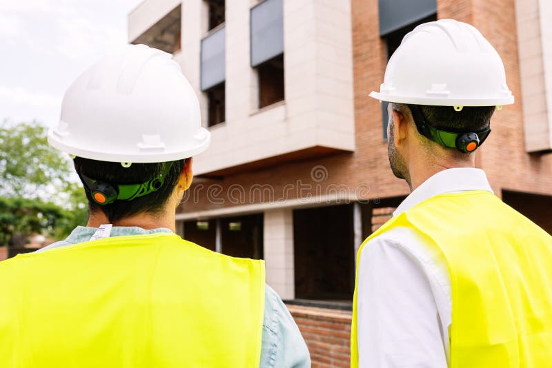 Two Engineer Architect Male Workers Working at Apartment Construction ...