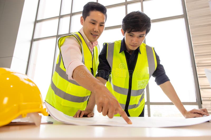 Two engineer reading plan stock image. Image of office - 177542697