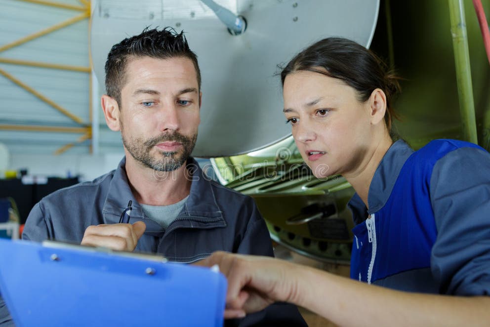 Two Engineering Colleagues in Discussion while Looking at Clipboard ...