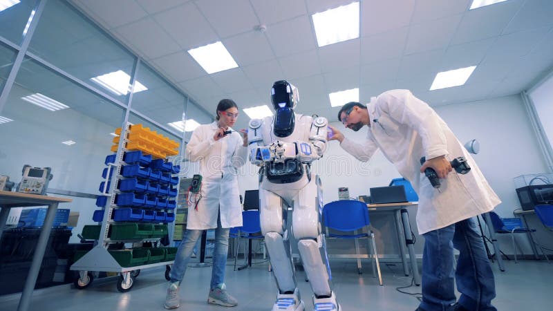 Two Engineers are Repairing a Human-like Robot Stock Video - Video of ...