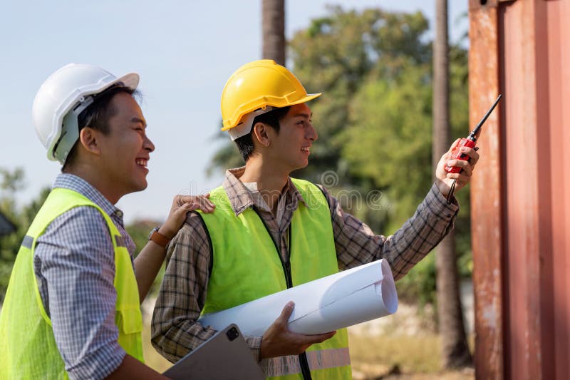 Engineers Collaborating on Construction Plans Outdoors with Blueprints ...