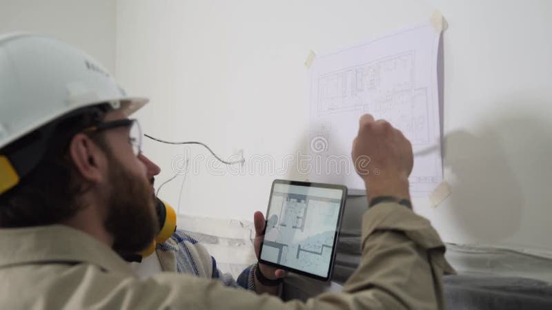 Two Engineers Discuss a Drawing that is Fixed on the Wall Stock Video ...