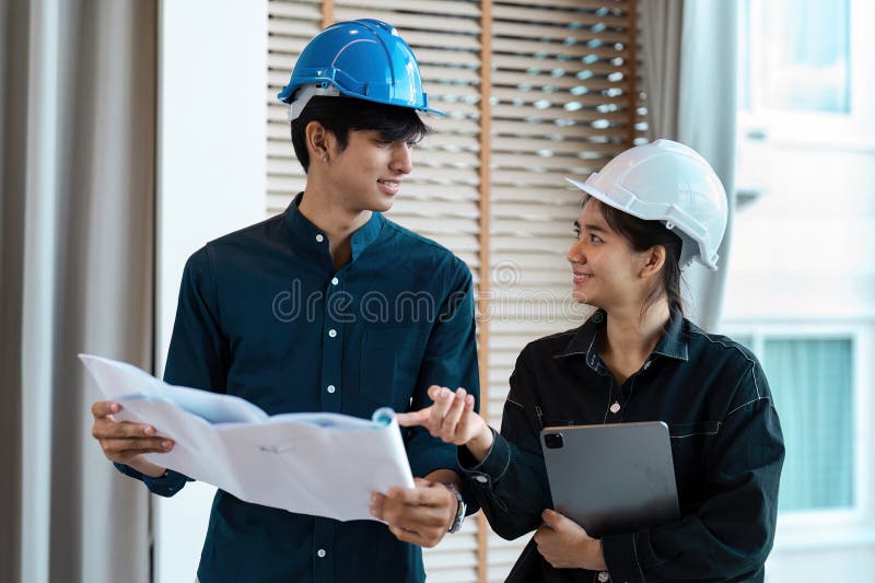 Two Engineers Discussing Blueprint and Project Plans at a Construction ...