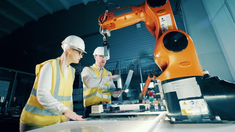Two Engineers in Hardhats Working with Modern Robot Stock Video - Video ...