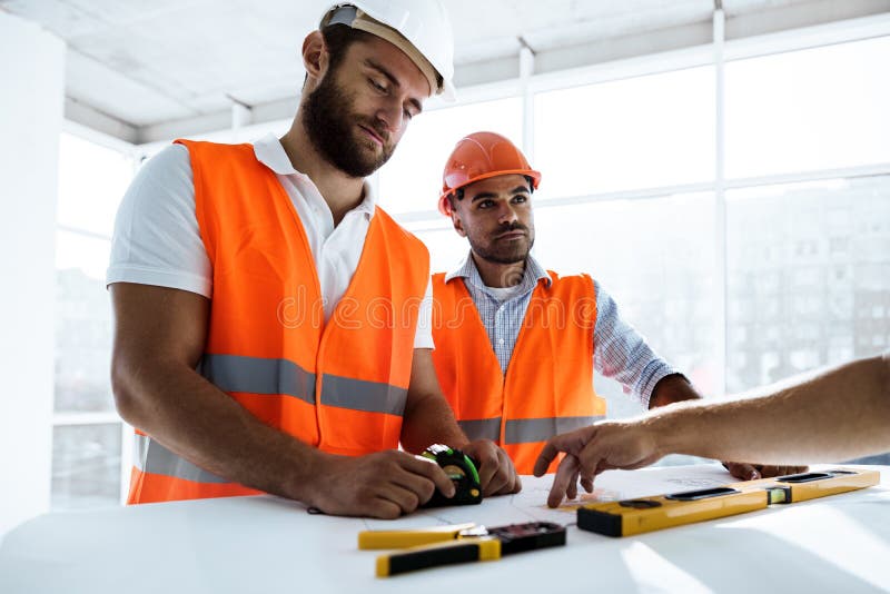 Two Engineers Man Looking at Project Plan on the Table in Construction ...