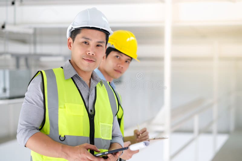 Two Engineers Man Standing in the Site. Engineer Holding Tablet and ...