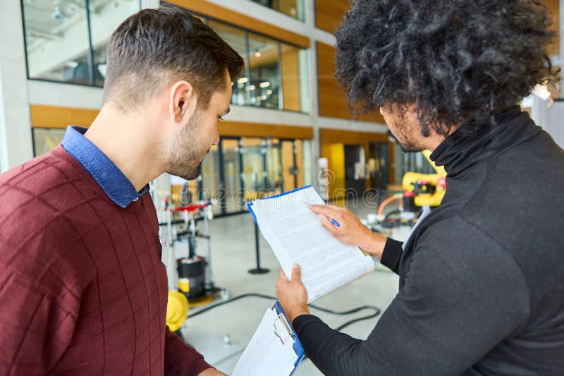 Engineers Examining Robotic Gripper Arm during Industrial Automation Training Session Stock ...
