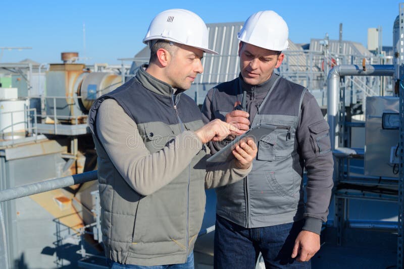 Two Engineers in Uniform and Helmets Talking Outdoors Stock Image ...