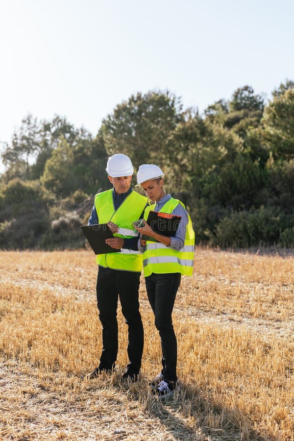 Two Engineers Working Together Outdoors in the Field. Stock Photo ...