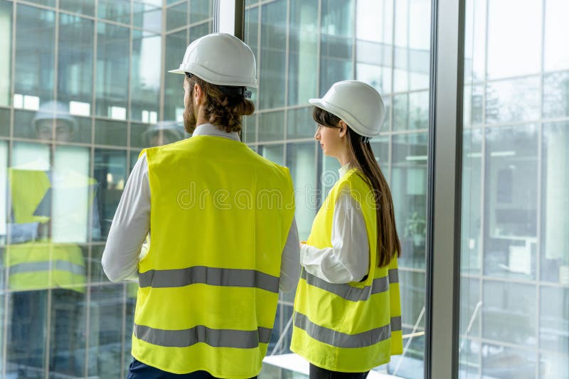 Two Engineers in Yellow Vests Standing at the Panoramic Window Stock ...