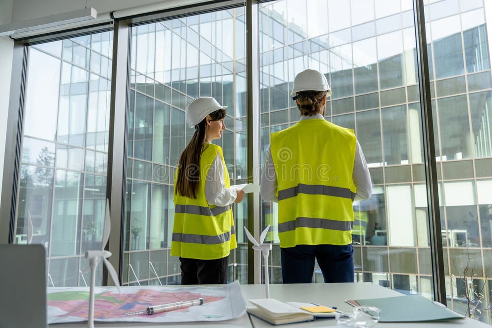 Two Engineers in Yellow Vests Standing at the Panoramic Window Stock ...
