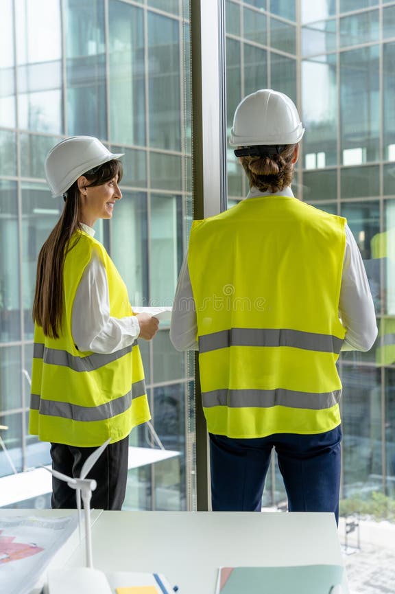 Two Engineers in Yellow Vests Standing at the Panoramic Window Stock ...