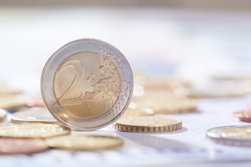 Two Euro Standing on Bank Notes and Coins Stock Photo - Image of ...