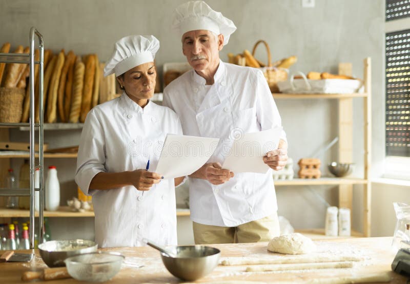 Two Experienced Bakers Read New Recipe on Paper, Discussing a Method ...