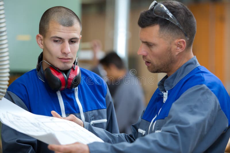 Two Experts Talking while Supervising Plans Stock Photo - Image of ...