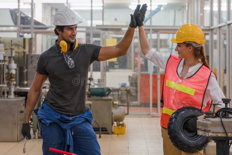 Two Factory Workers Having Highfive Together Showing Teamwork of ...