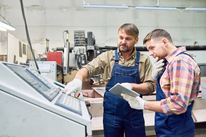 Two Factory Workers Operating Machines Stock Photo - Image of ...