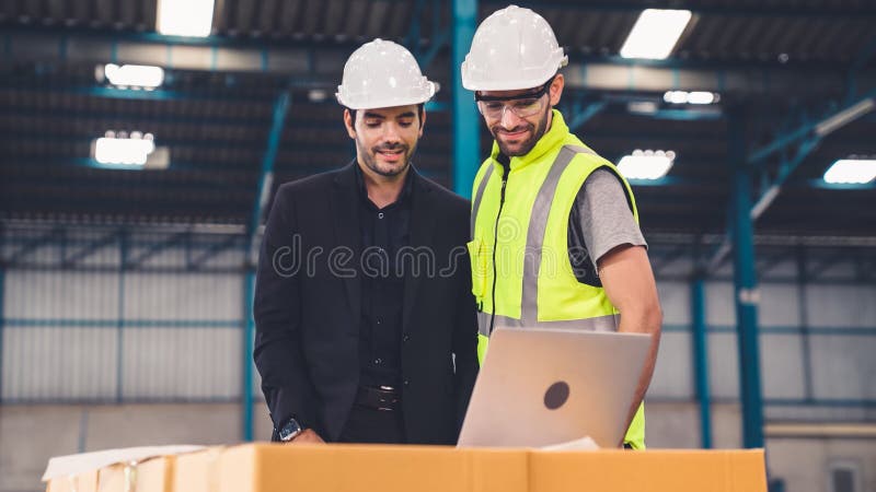 Two Factory Workers Working and Discussing Manufacturing Plan in the ...