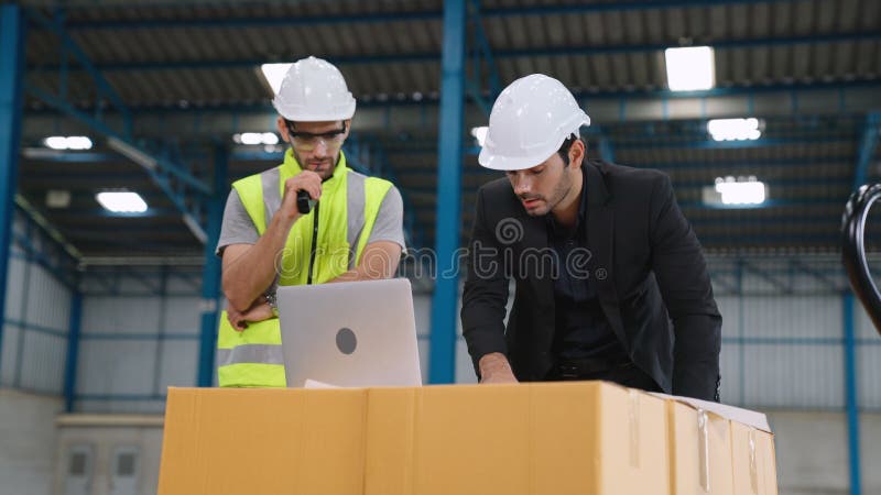 Two Factory Workers Working and Discussing Manufacturing Plan in the ...