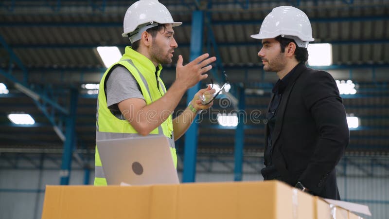 Two Factory Workers Working and Discussing Manufacturing Plan in the ...