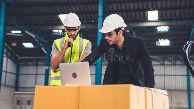 Two Factory Workers Working and Discussing Manufacturing Plan in the ...