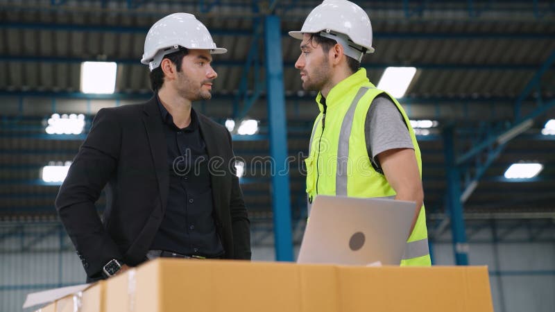 Two Factory Workers Working and Discussing Manufacturing Plan in the ...