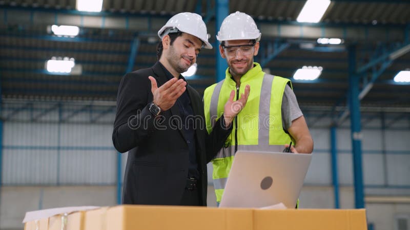 Two Factory Workers Working and Discussing Manufacturing Plan in the ...