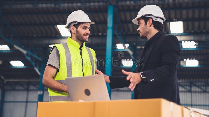 Two Factory Workers Working and Discussing Manufacturing Plan in the ...