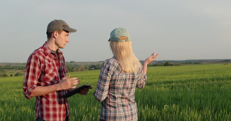Two Farmers Talk on the Field, Then Shake Hands. Use a Tablet Stock ...
