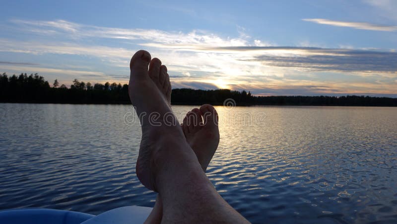 Two Feet Silhouetted Against the Water in Front of the Sunset Stock ...