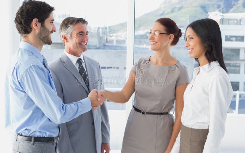 Two Fellow Employees Shaking Hands Stock Photo - Image of four, indoors ...