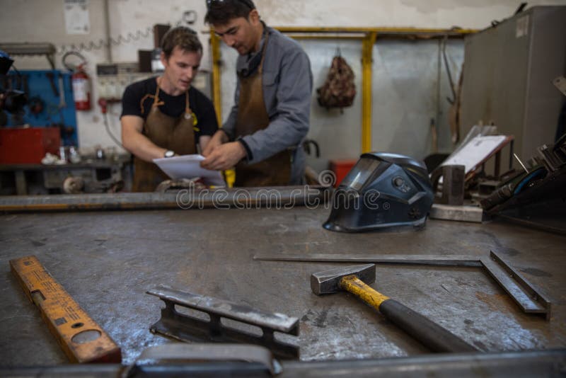 Two Fellow Workers Look at the Technical Drawings in the Factory, Focus ...
