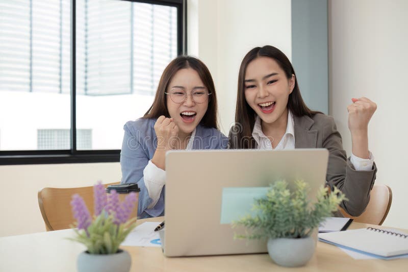 Two Female Accountant Collaborating on Financial Graphs and Data ...